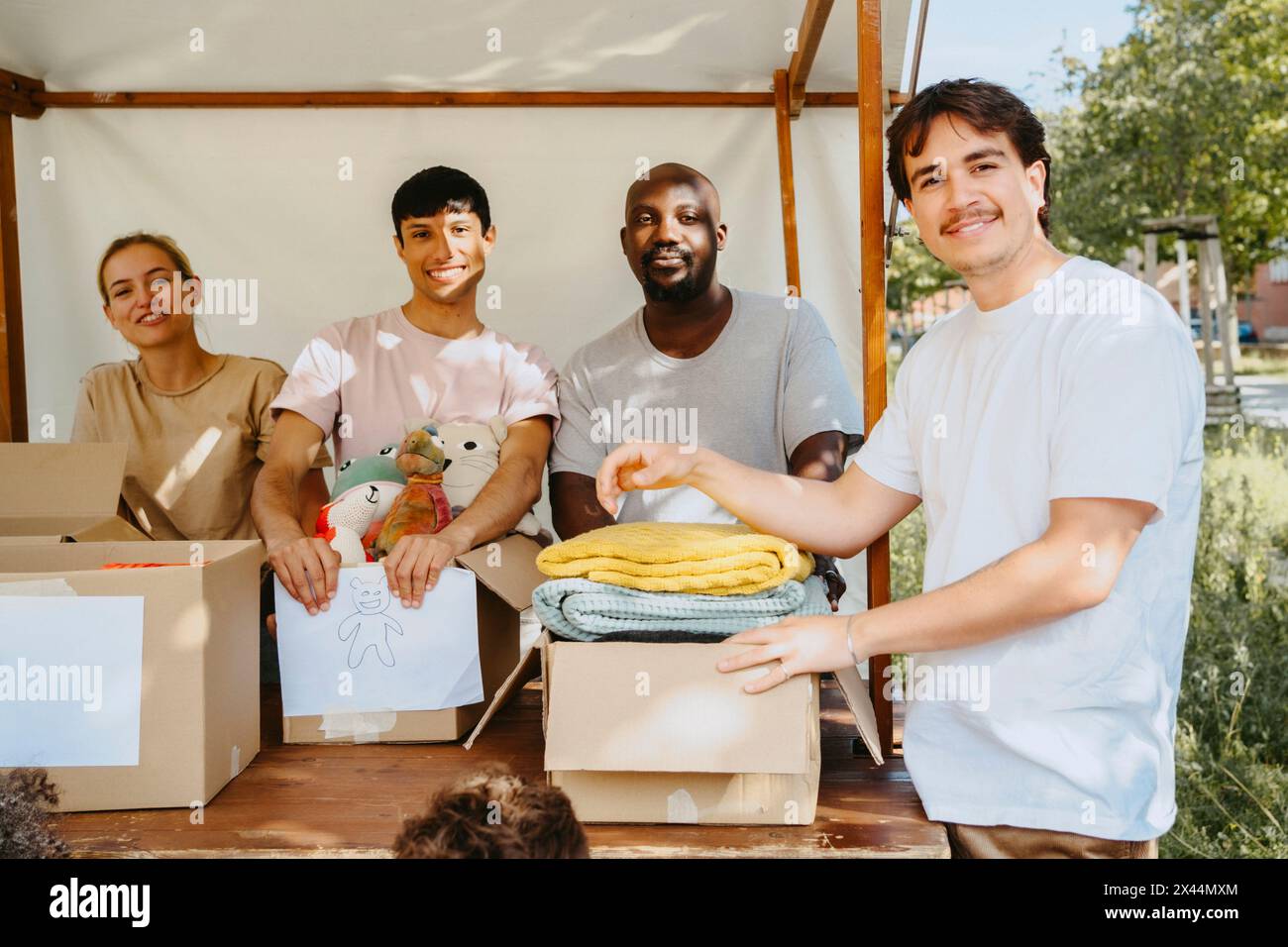 Portrait of diverse male and female volunteers posing with donation ...