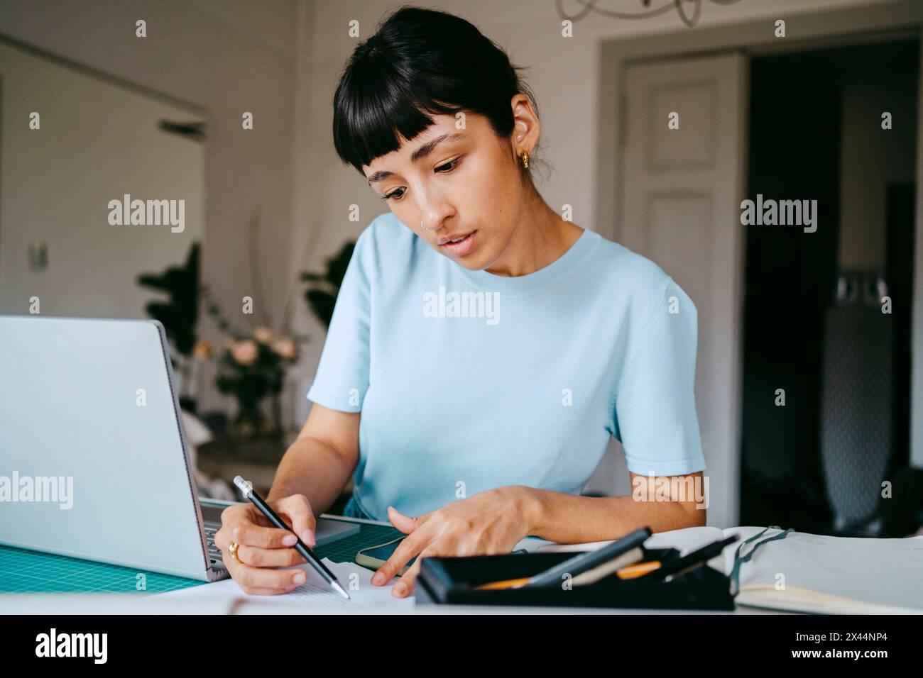Female business professional planning strategy at desk with laptop in ...