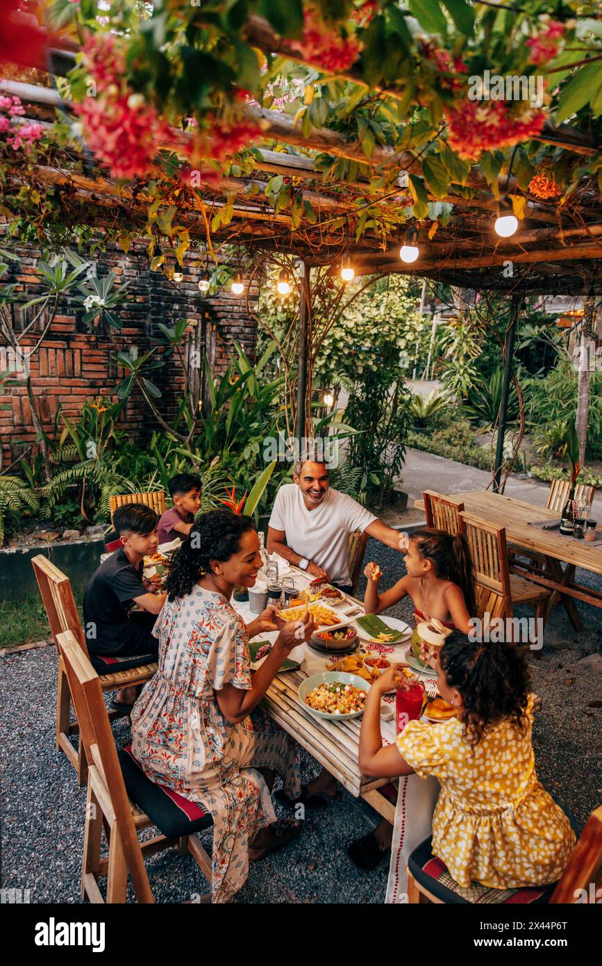 Happy family having food while sitting at dining table in resort on ...