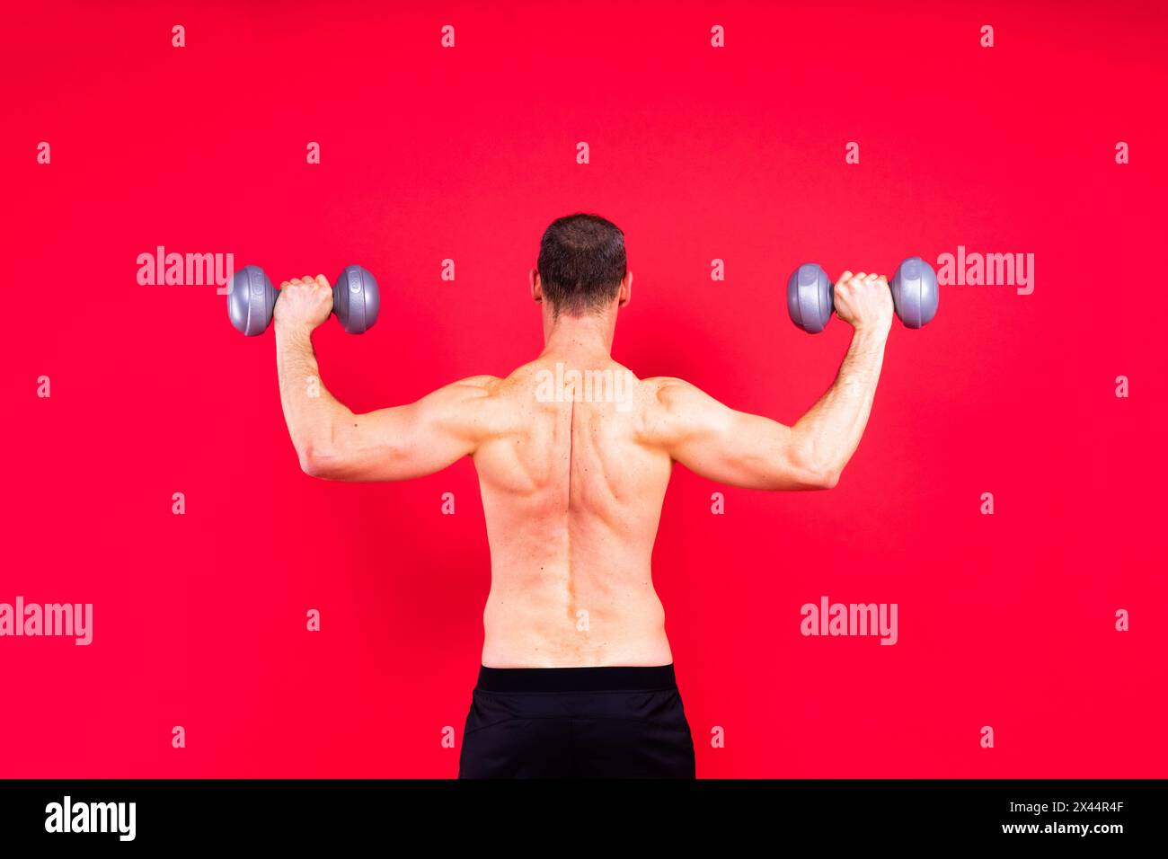 Exercising weight training man with a dumbbell isolated studio ...