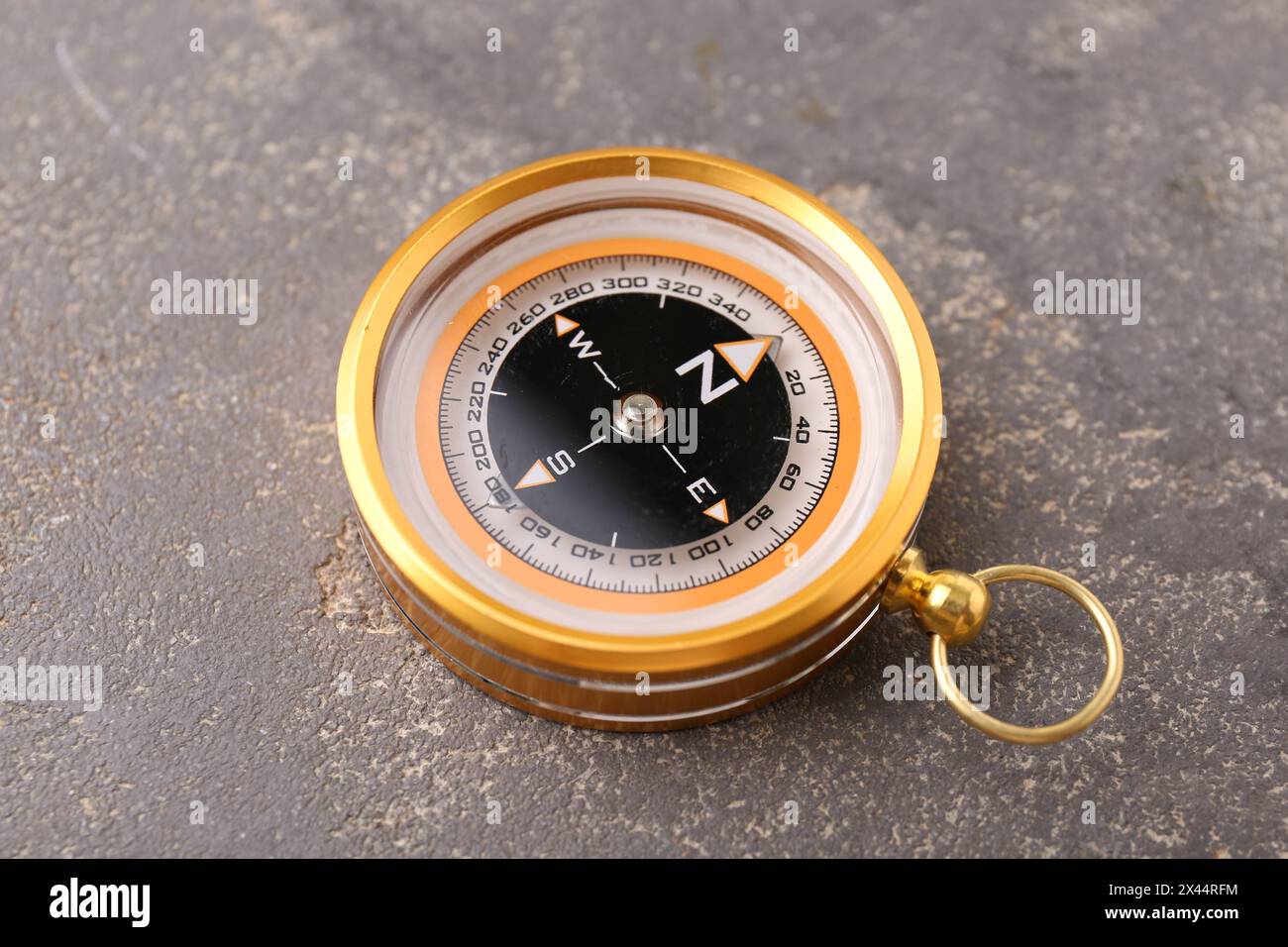 One compass on grey textured background, closeup. Navigation equipment ...