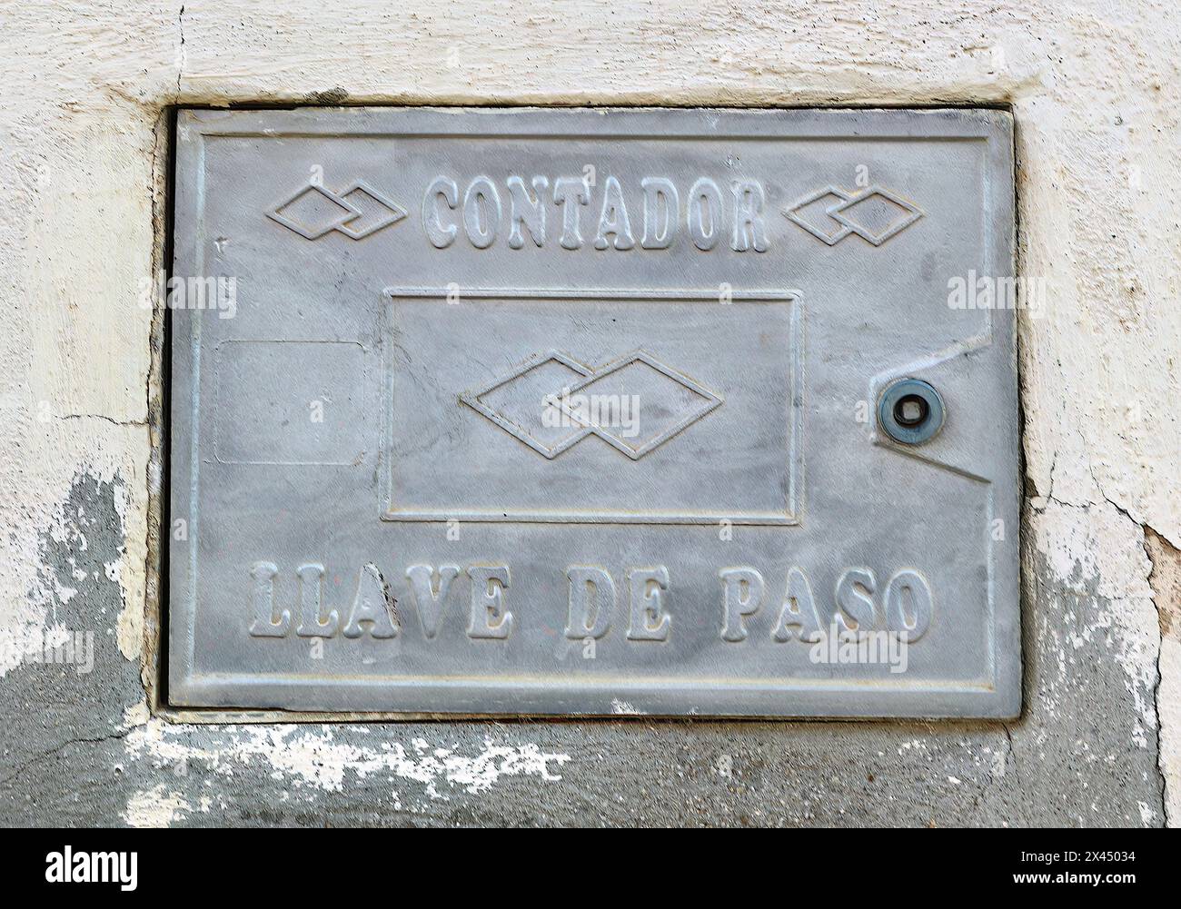 Wall mounted metal door in the street for a water meter in Spain close ...