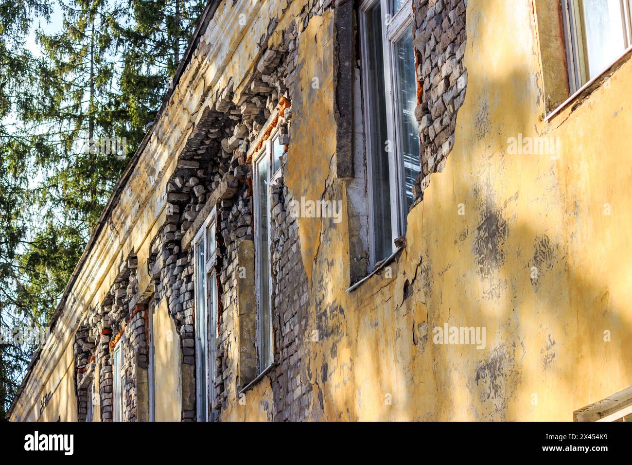 Collapsing wall of a dilapidated brick building, falling out bricks ...