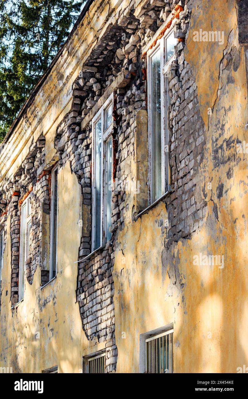 Collapsing wall of a dilapidated brick building, falling out bricks ...