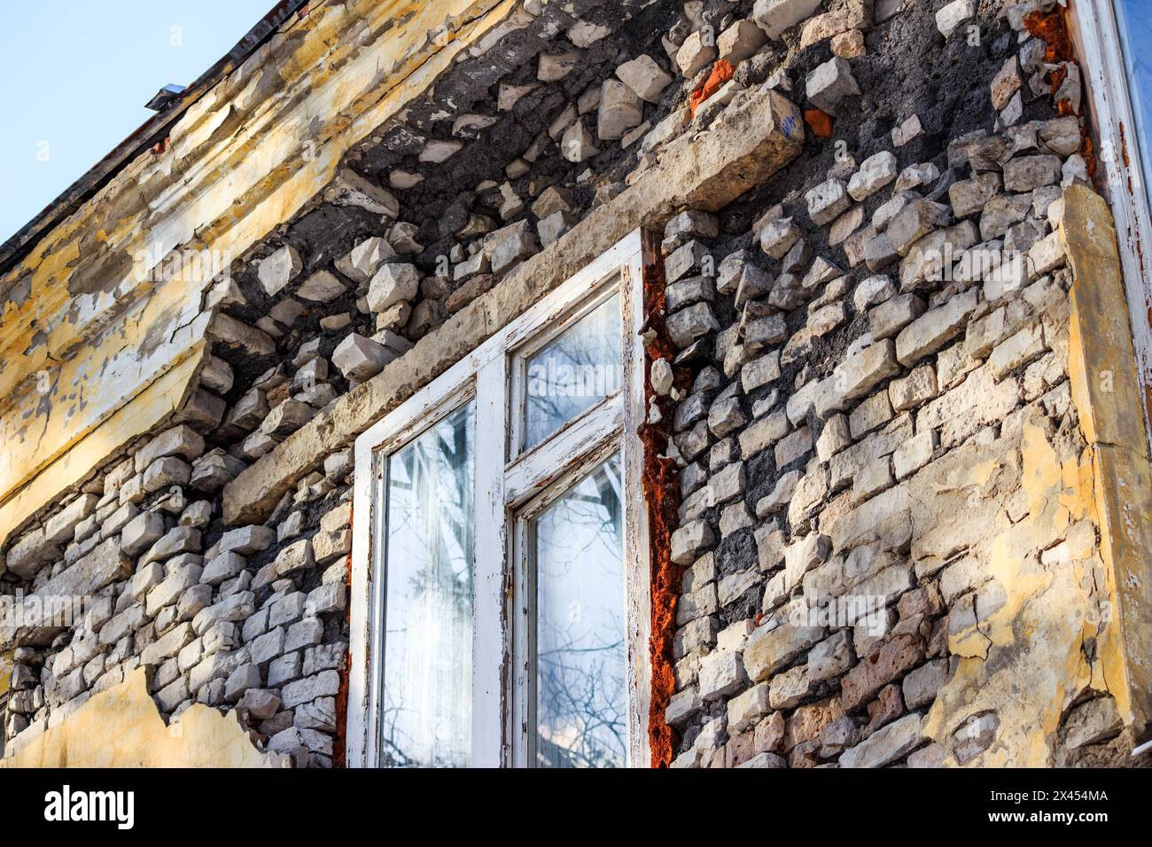 Collapsing wall of a dilapidated brick building, falling out bricks ...