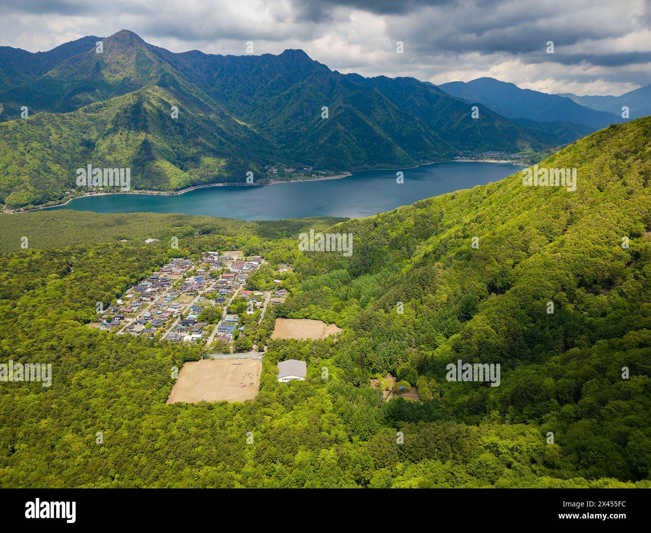 Drone view of lush forest, rugged mountains and a small lake Stock ...