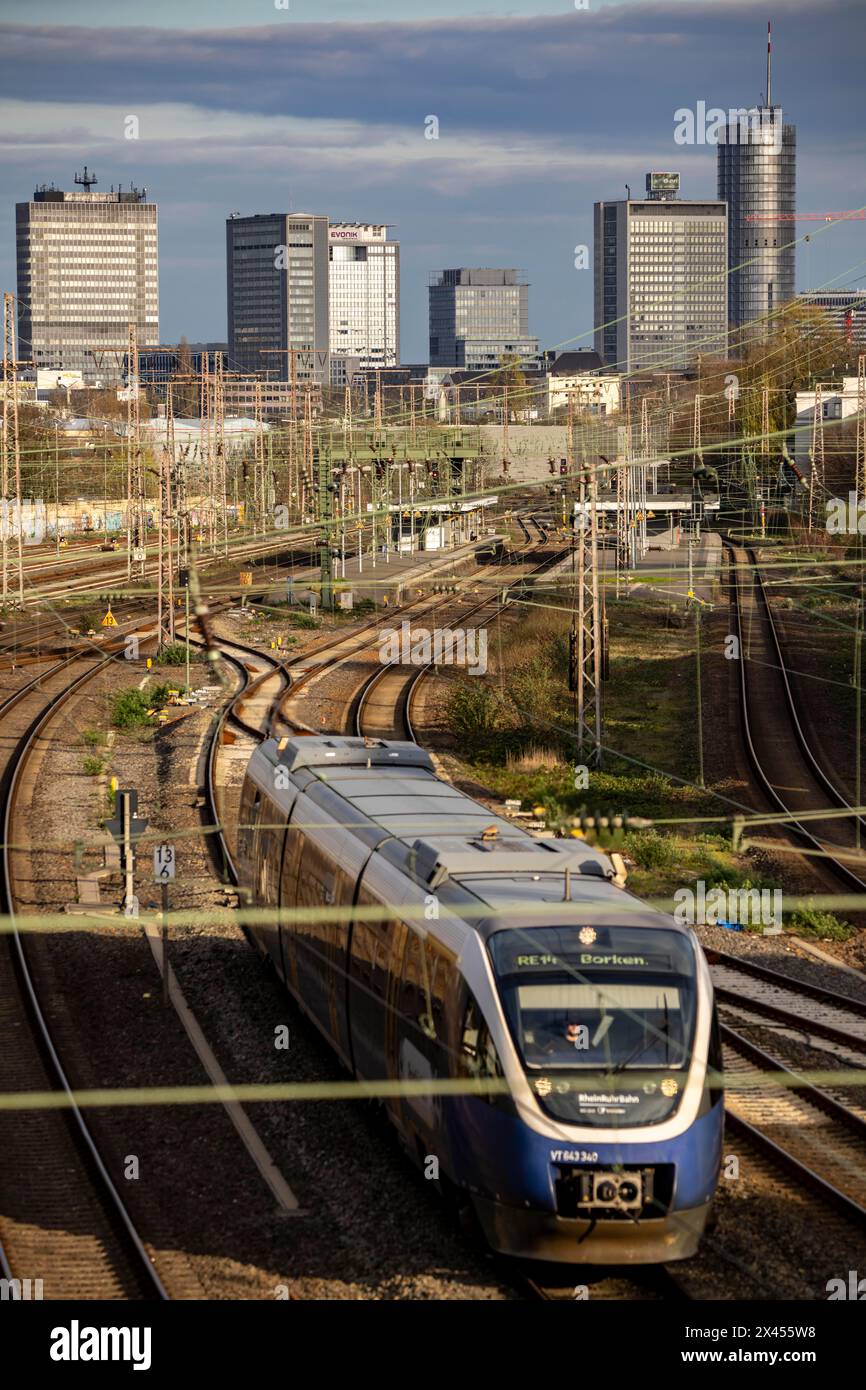 Train on the tracks west of the main station of Essen, skyline of the ...