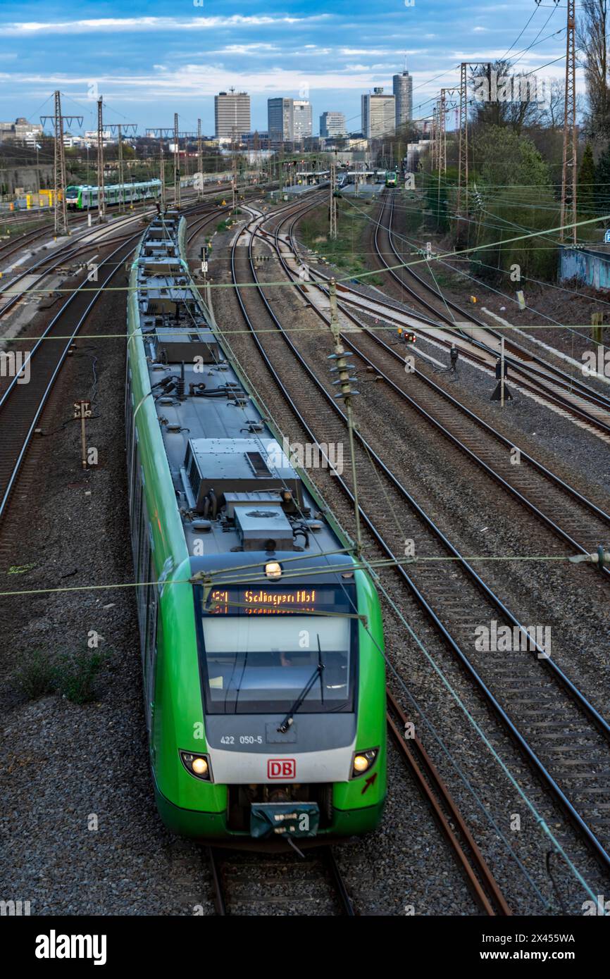 Train on the tracks west of the main station of Essen, skyline of the ...