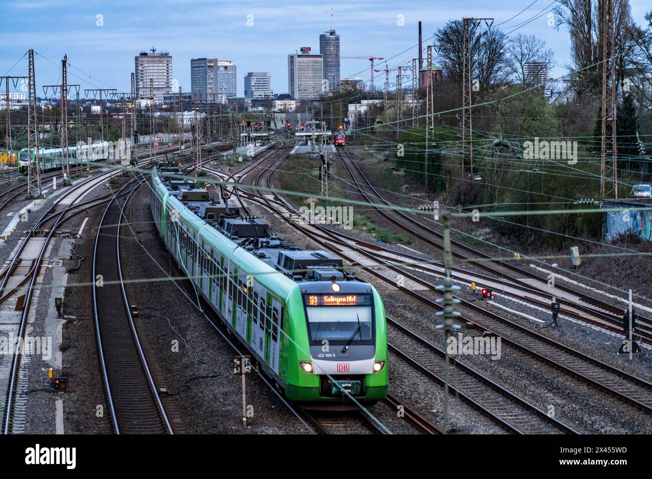 Train on the tracks west of the main station of Essen, skyline of the ...