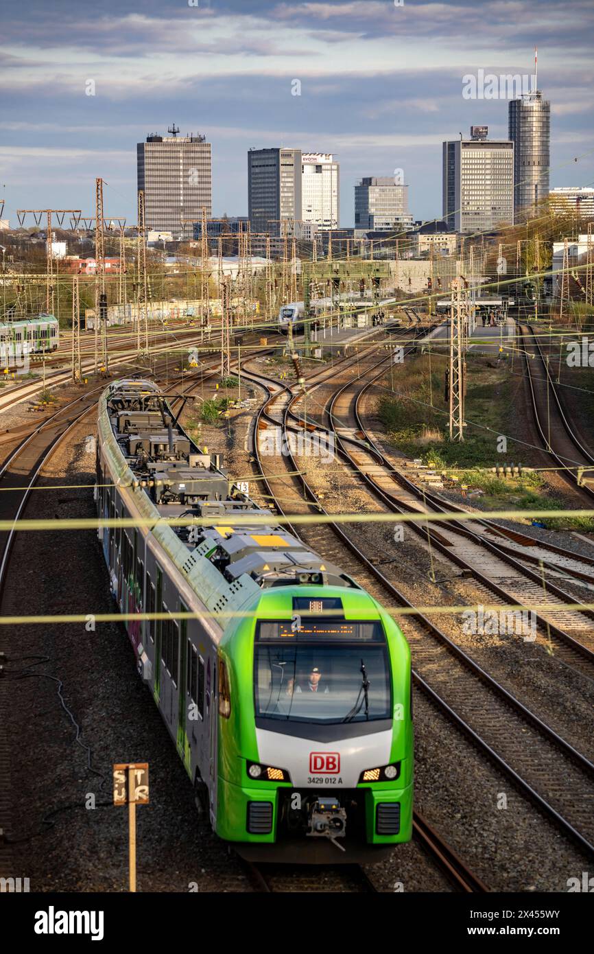 Train on the tracks west of the main station of Essen, skyline of the ...