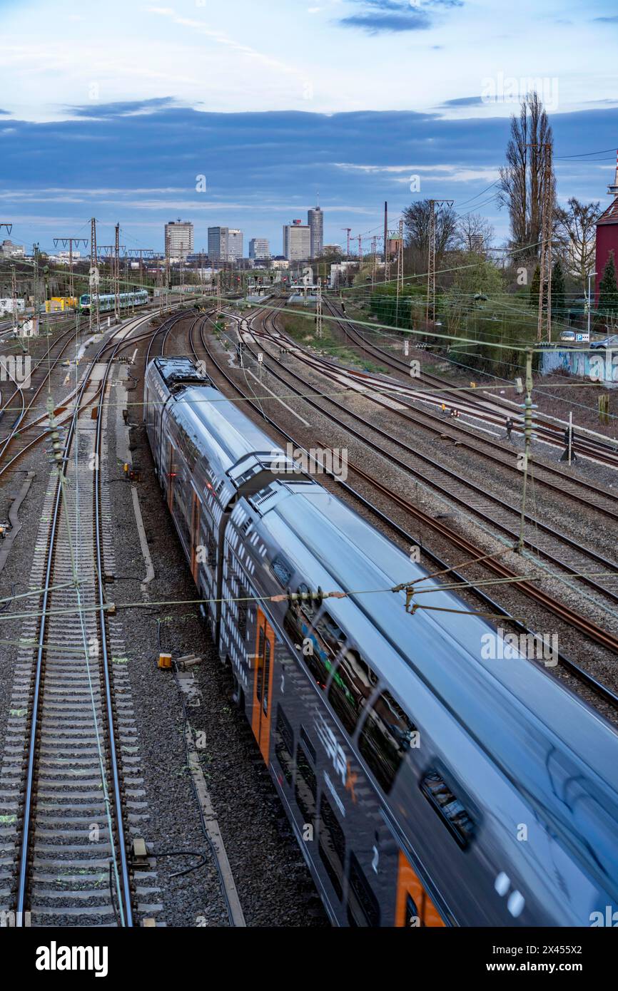 Train on the tracks west of the main station of Essen, skyline of the ...