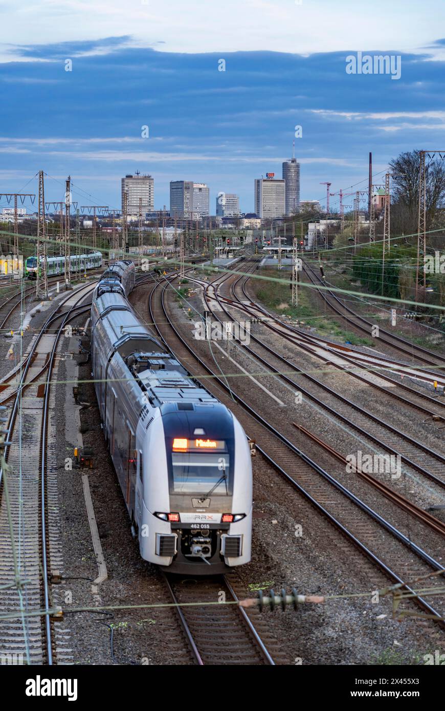 Train on the tracks west of the main station of Essen, skyline of the ...