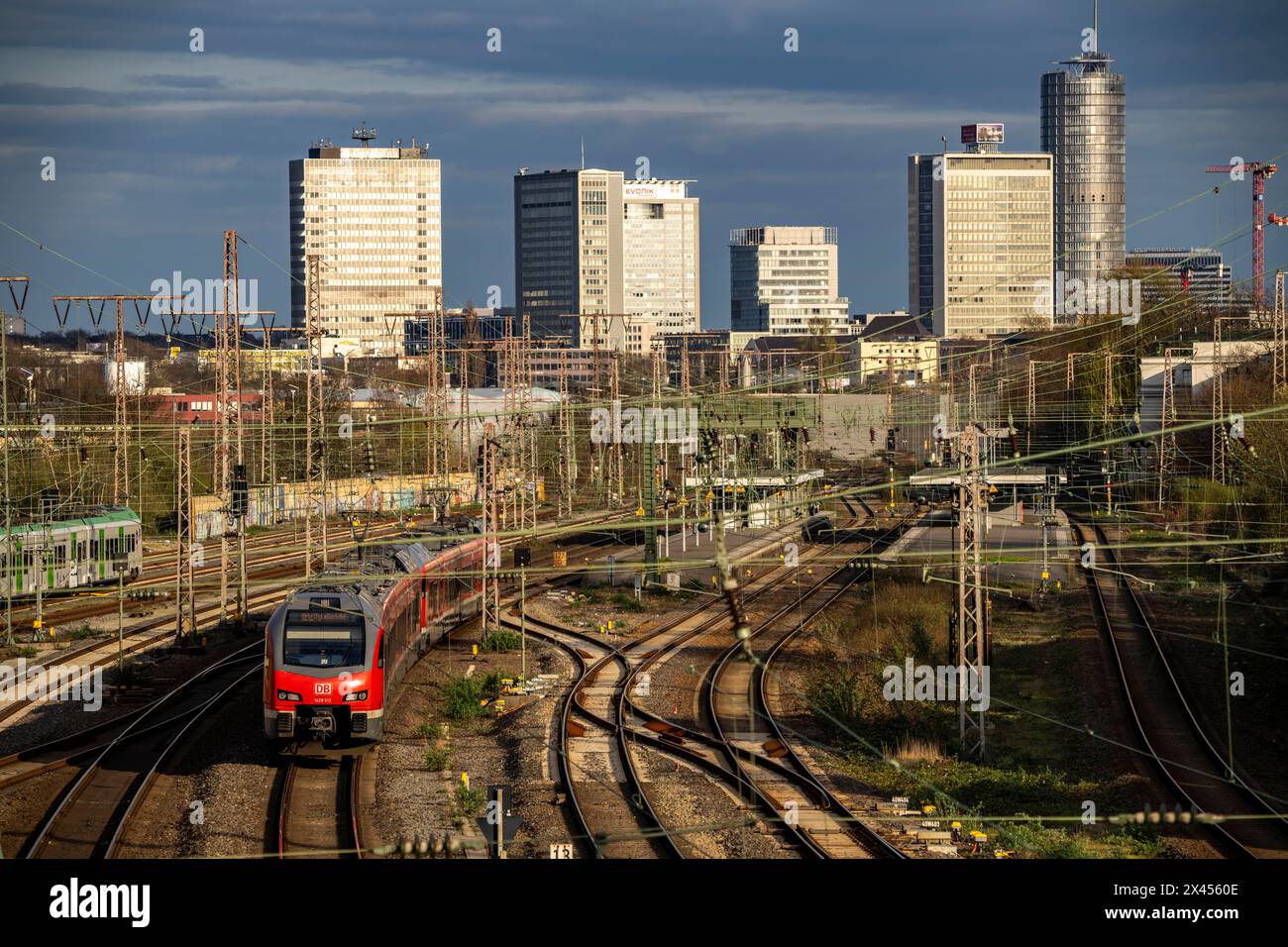Train on the tracks west of the main station of Essen, skyline of the ...