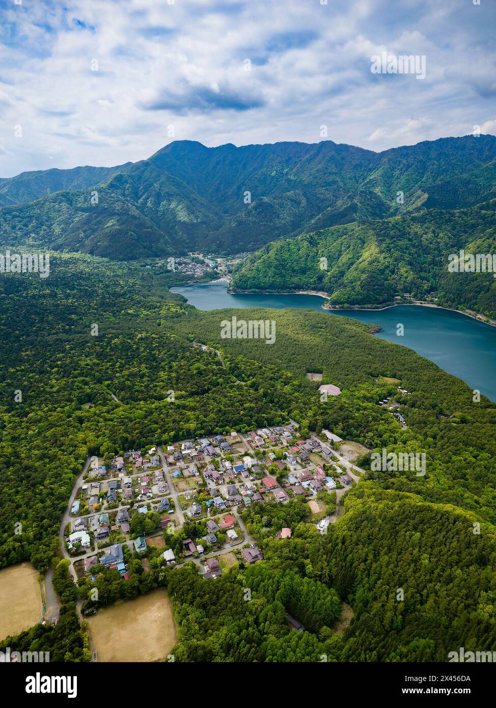 Small village surrounded by lush forest and rugged mountains next to a ...