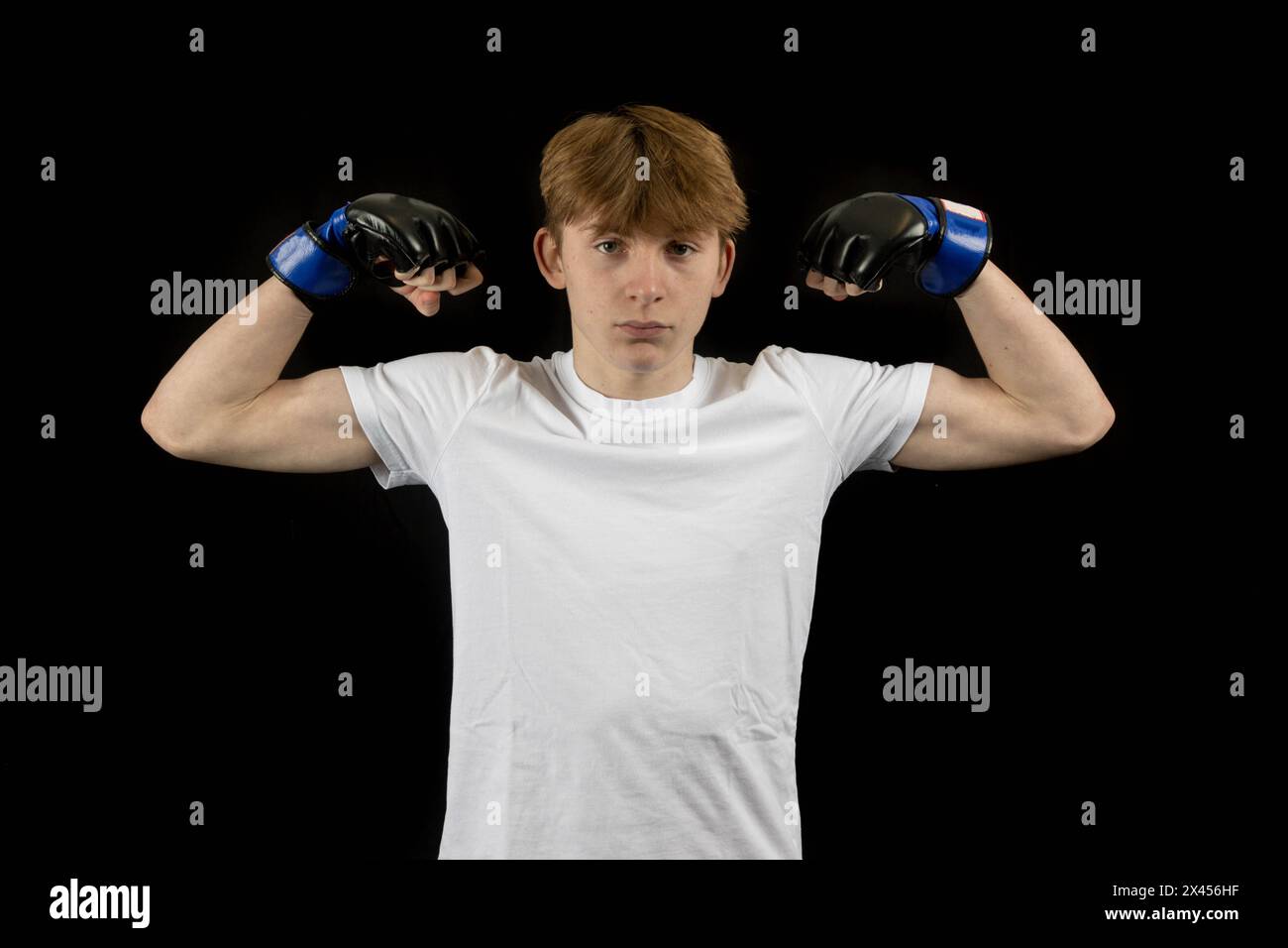 A 15 year old male teenager boxer, against a black background, wearing ...