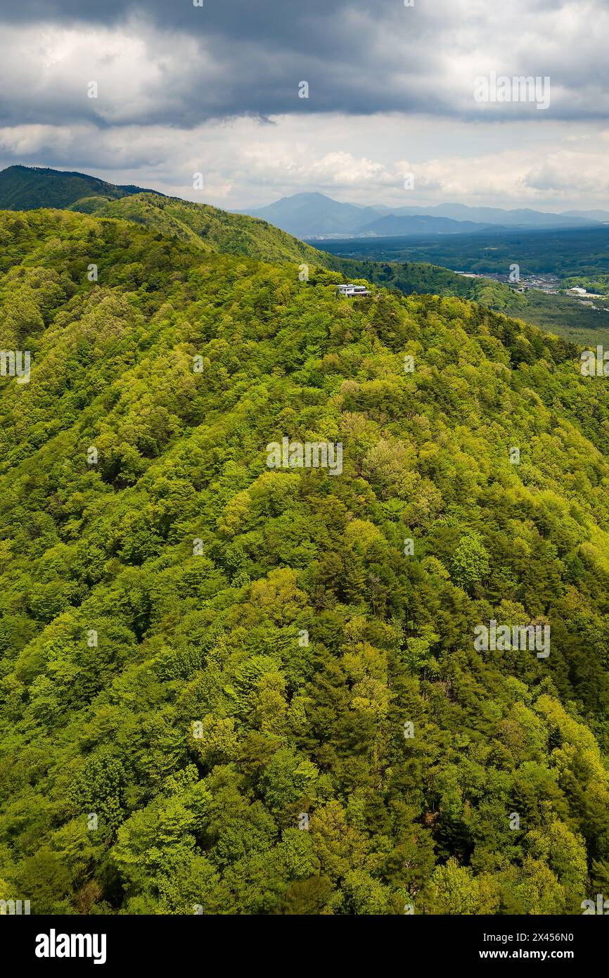 Aerial view of a mountain ridge covered in lush green forest next to a ...
