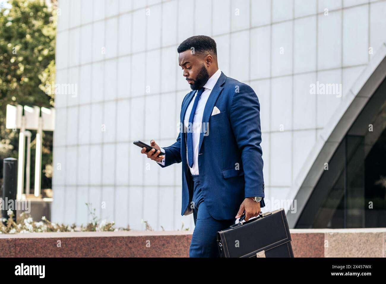 Business black man in suit leaving the office holding his work ...