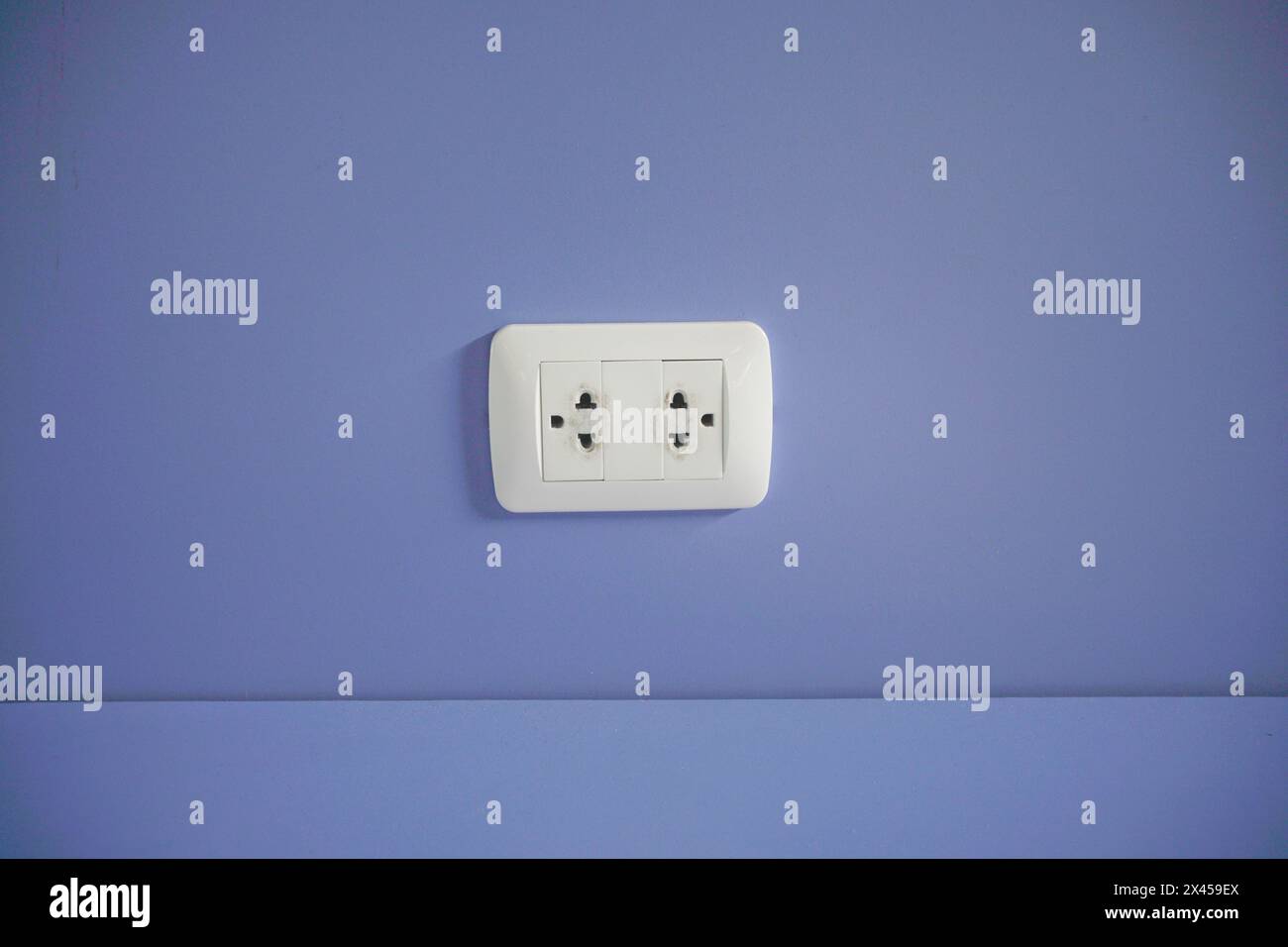 Old electric plug on blue wall Stock Photo - Alamy