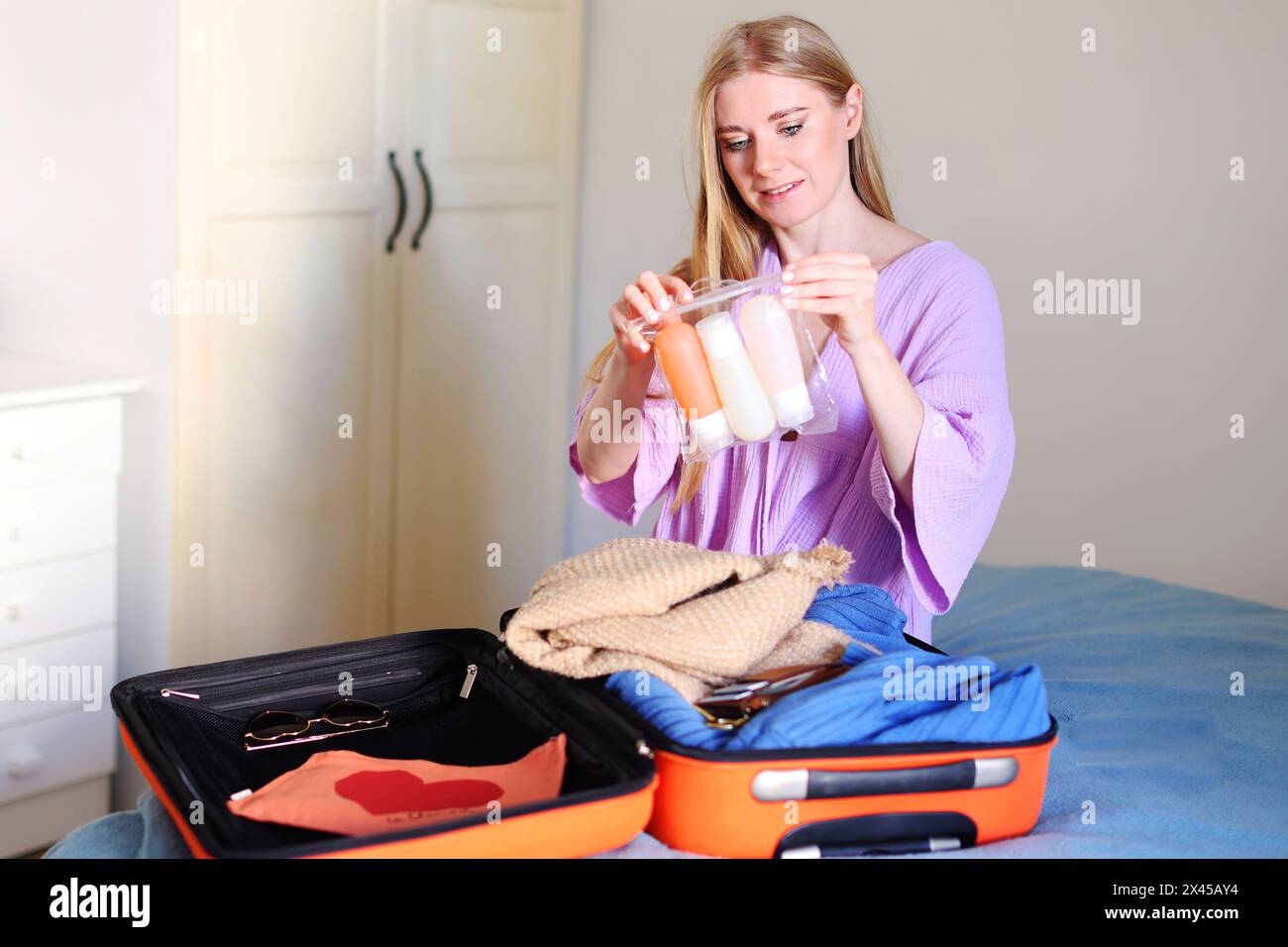 girl packing suitcase cosmetics packaging for airplane for hand luggage ...