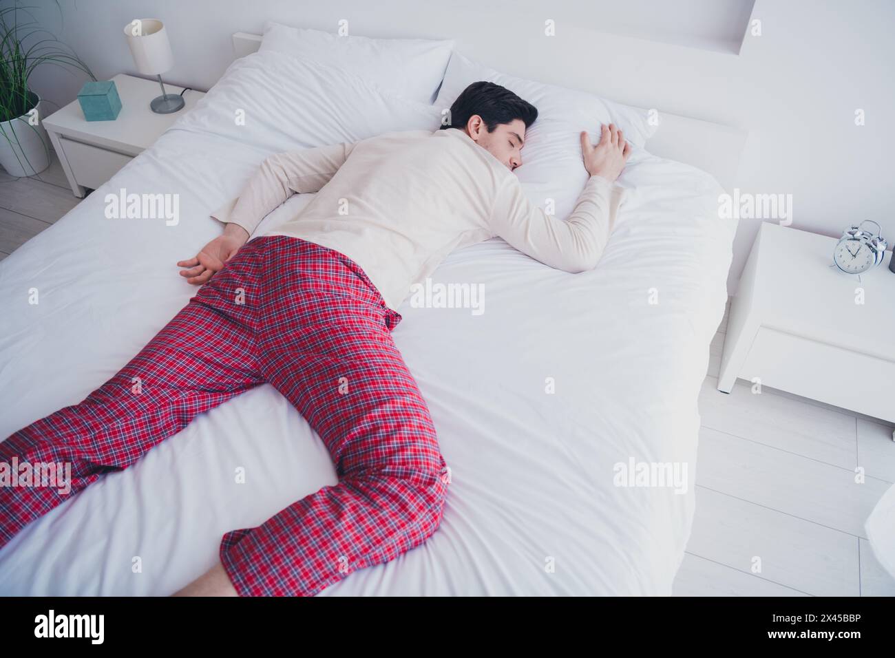 Photo of young attractive man sleeping lying alone in soft comfy bed ...