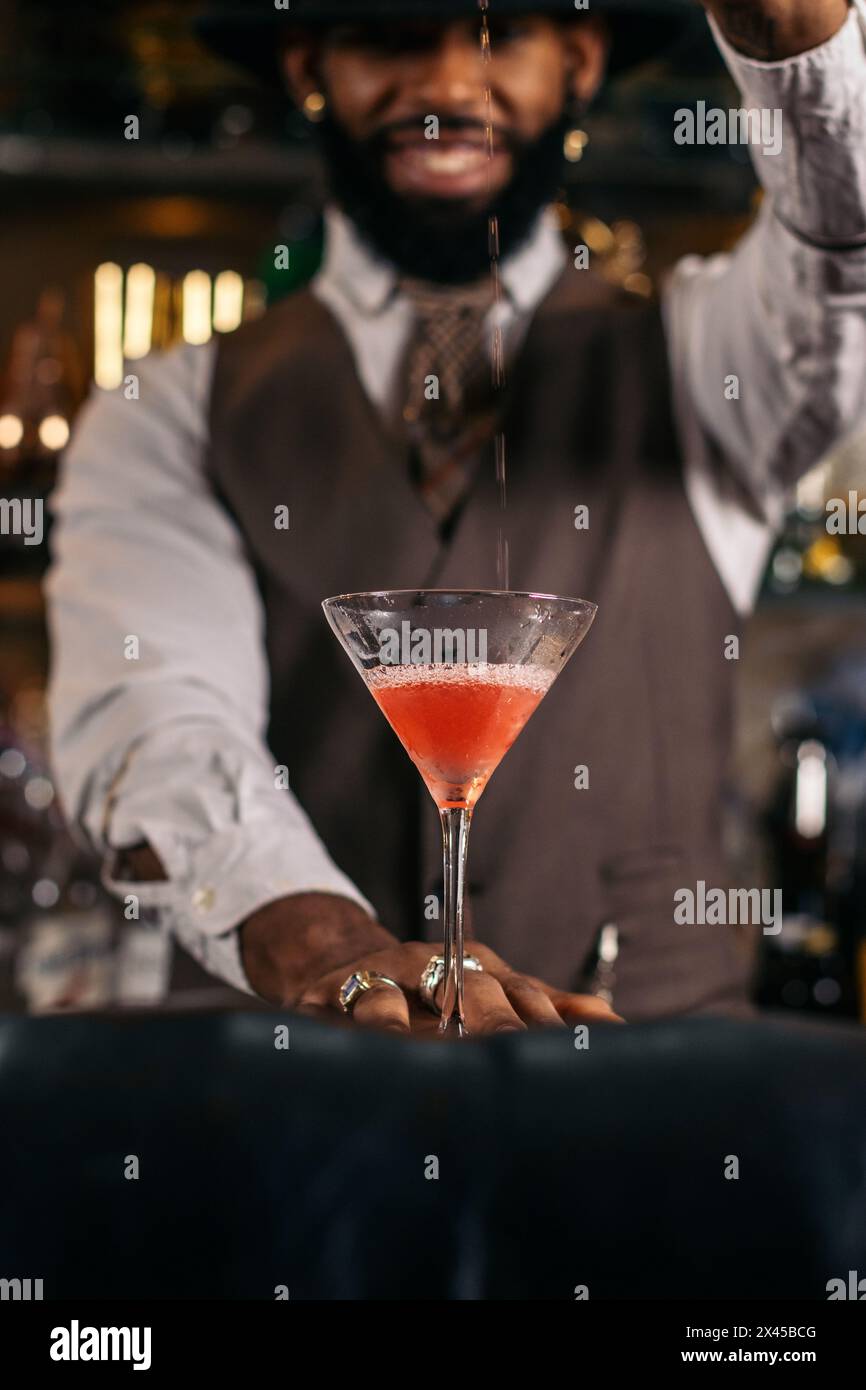 Black bartender preparing a cocktail in a traditional cocktail bar ...
