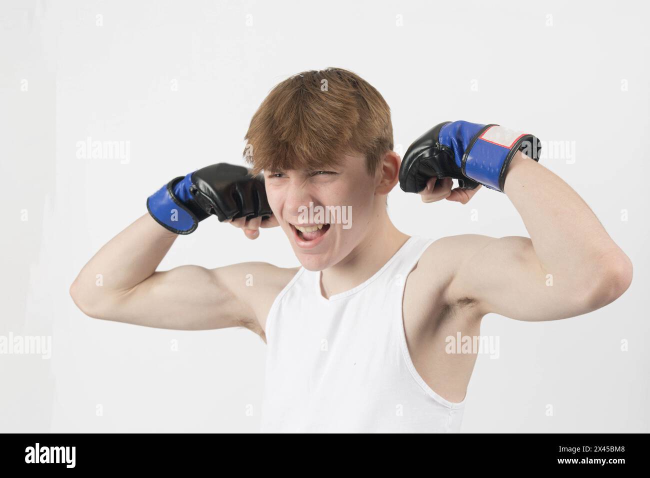 A 15 year old male teenager boxer, wearing a sleeveless top, flexing ...