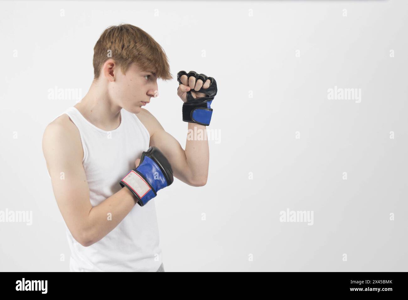 A 15 year old male teenager boxer, wearing a sleeveless top, with his ...