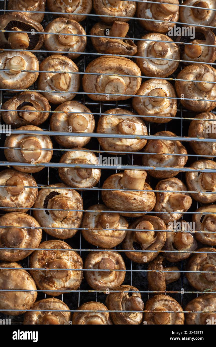 Mushrooms grilling on gas cooker close up, tasty finger food cooking ...