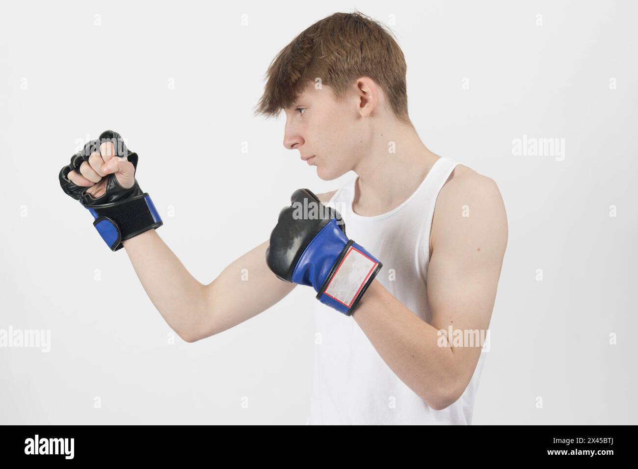 A 15 year old male teenager boxer, wearing a sleeveless top, with his ...