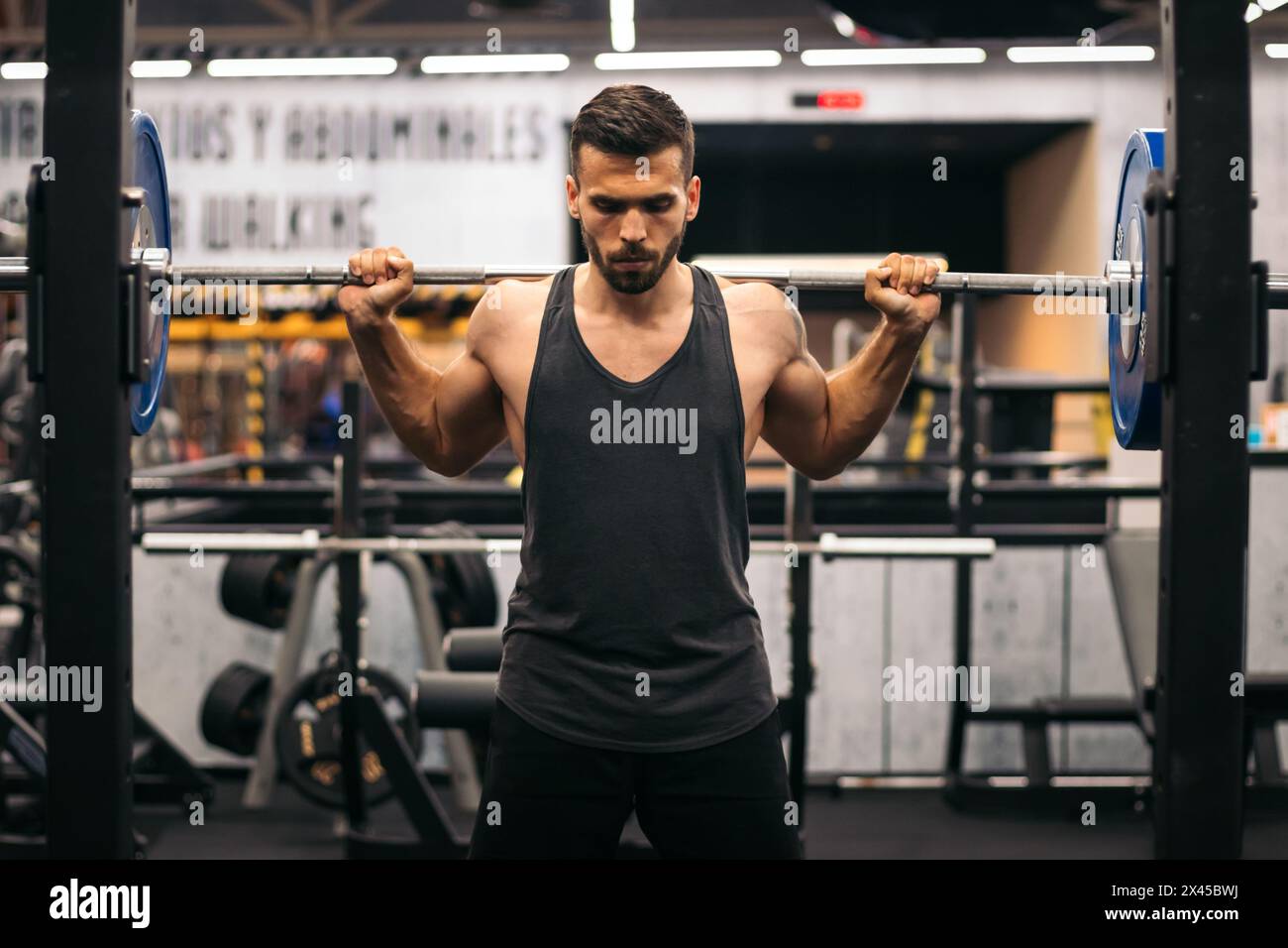 concentrated man athlete doing squats in a gym. front view Stock Photo ...