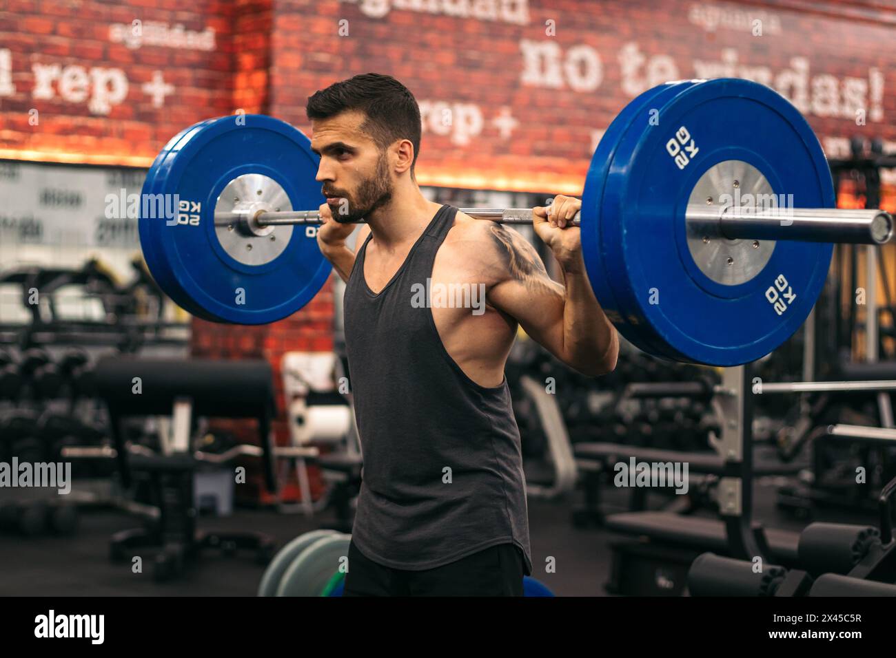 concentrated man athlete doing squats in a gym. front view Stock Photo ...