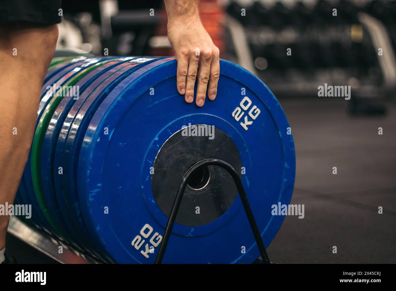 man taking a weight plate in a gym Stock Photo - Alamy