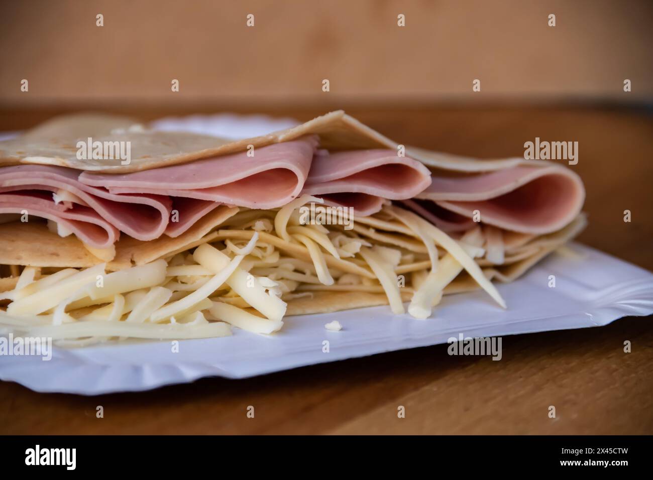 A savory pancake filled with ham and melted cheese offers a delightful ...