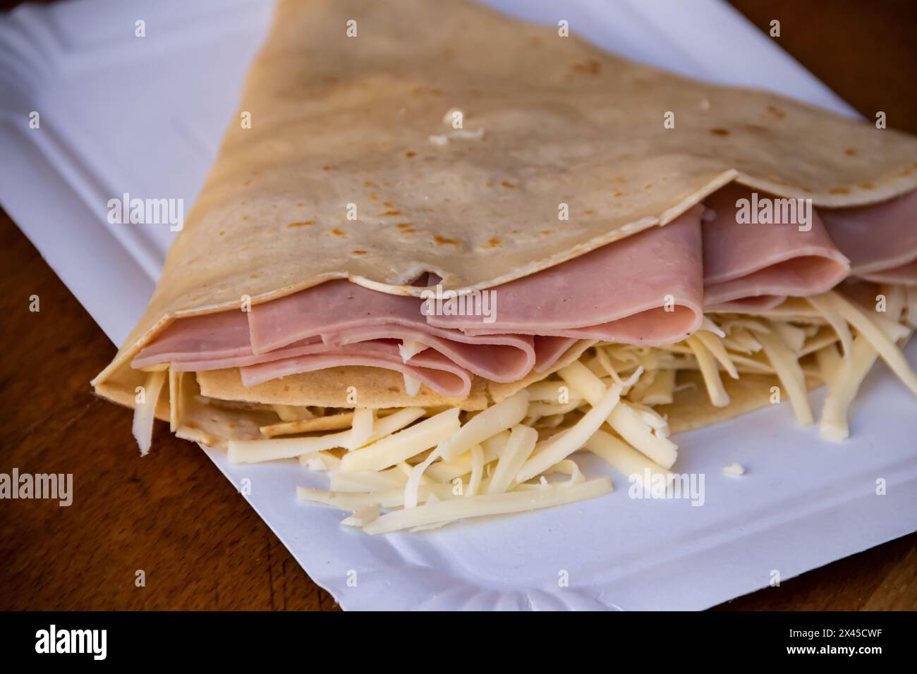 A savory pancake filled with ham and melted cheese offers a delightful ...