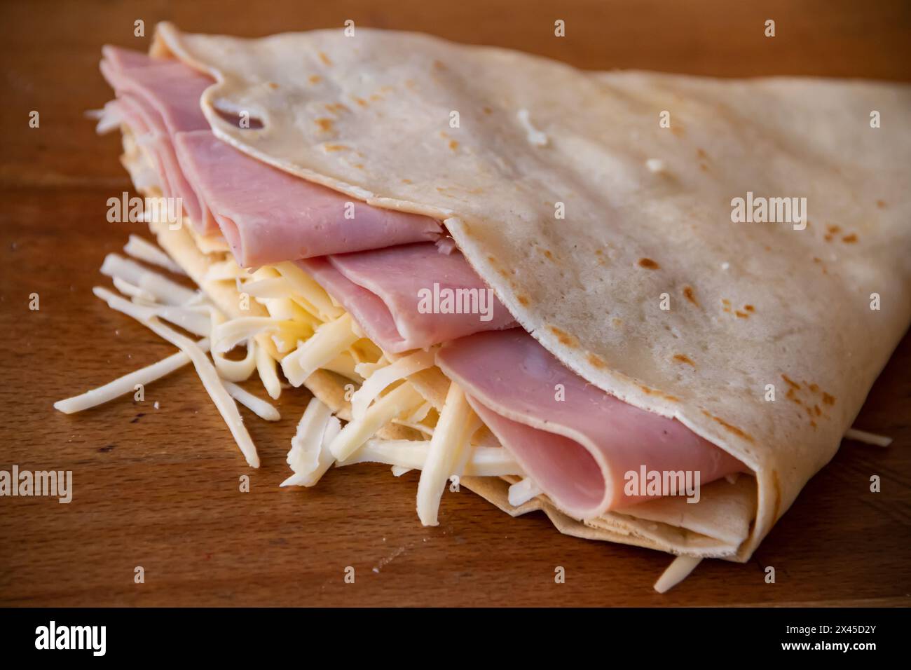 A savory pancake filled with ham and melted cheese offers a delightful ...