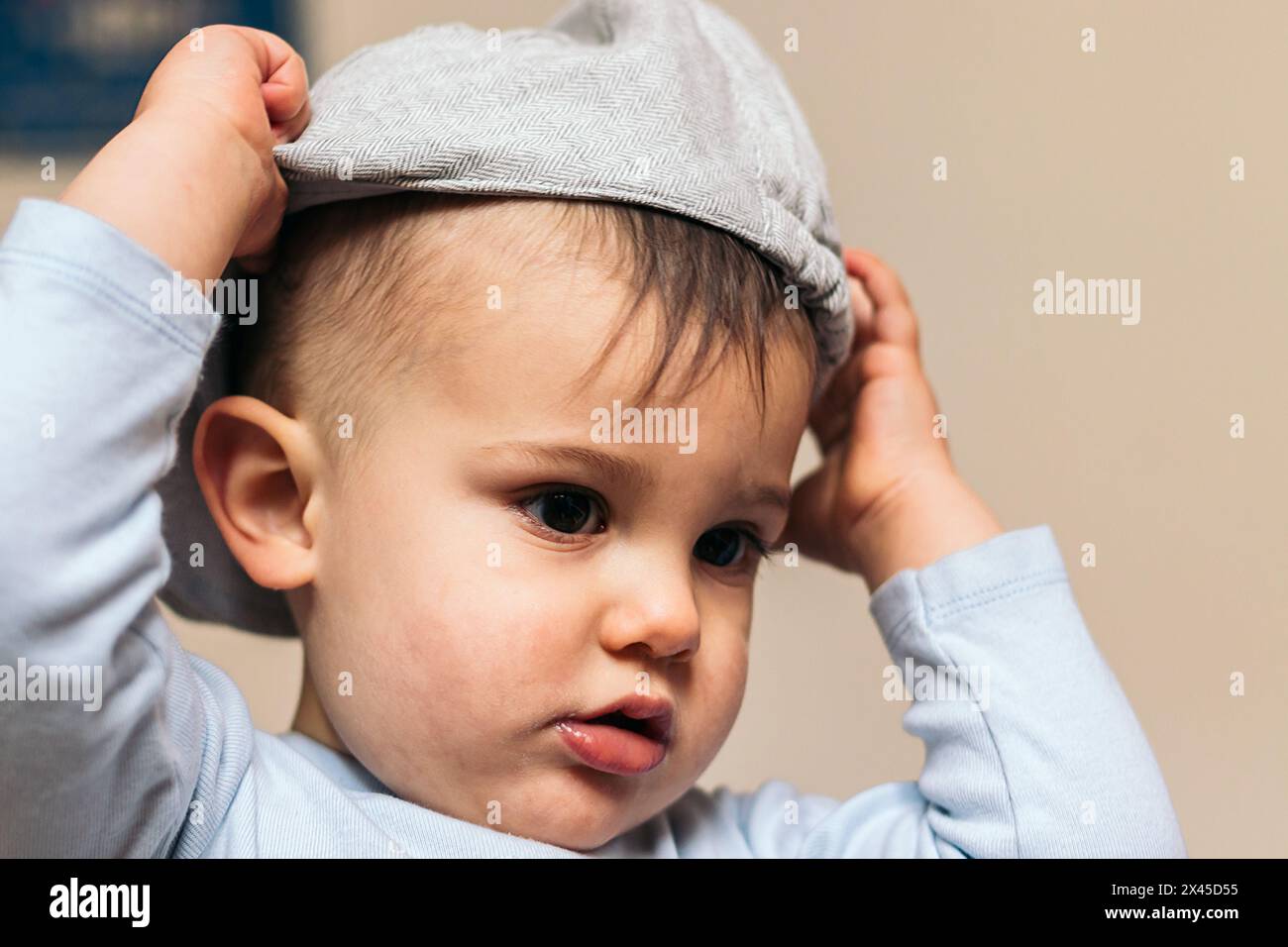 cute baby putting on a hat at home Stock Photo - Alamy