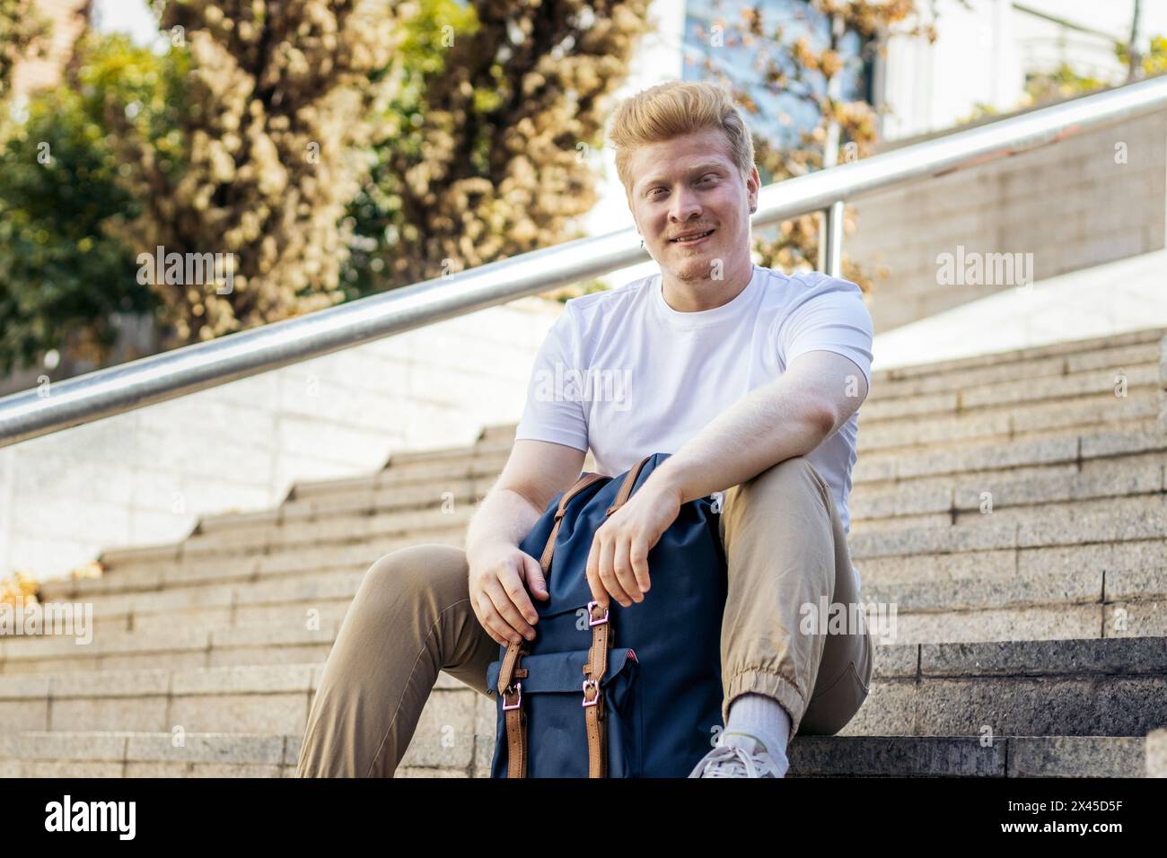 Albino latin man wearing white clothes sitting on a staircase in the ...