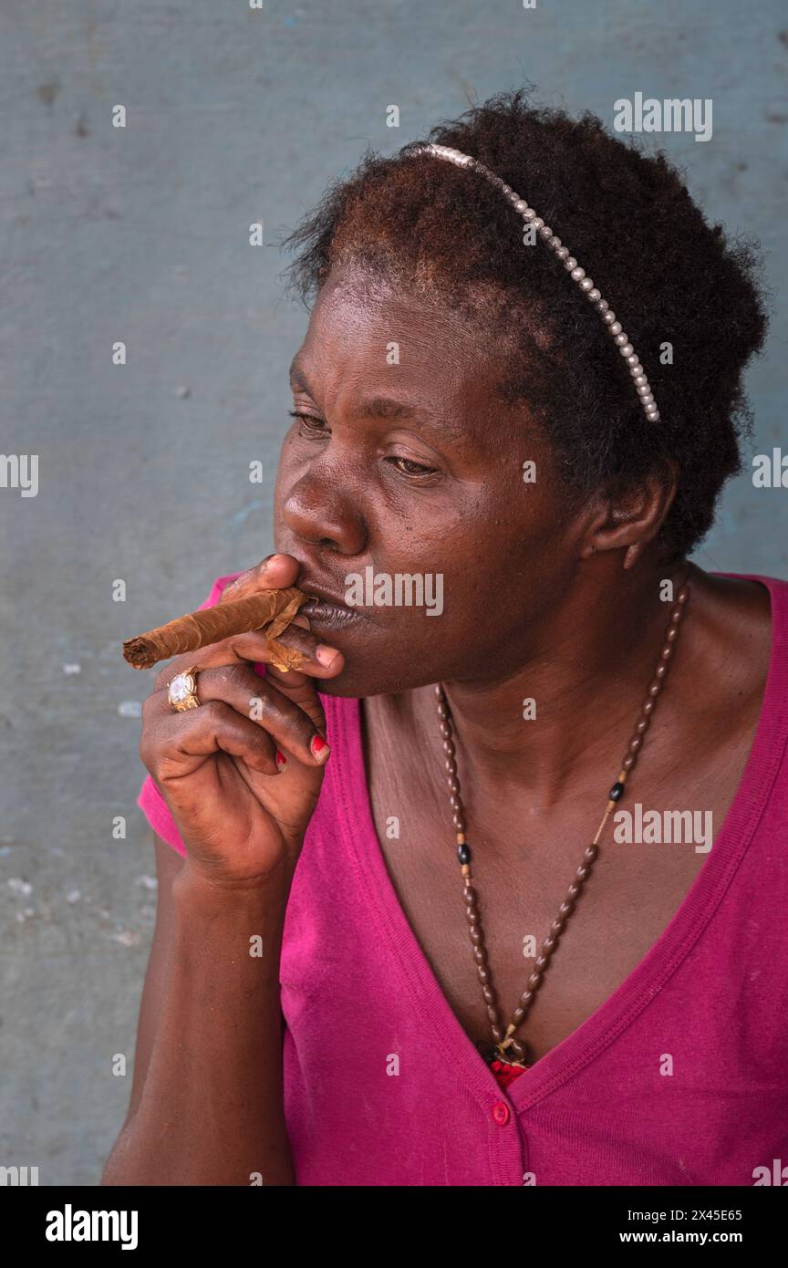 The wife of a farmer smoking a cigar outside her farmhouse in the ...