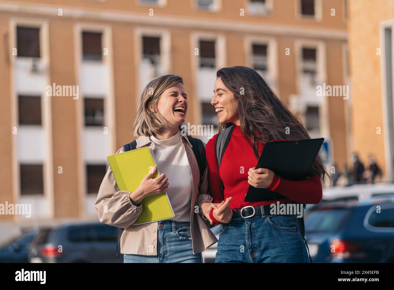 Two student girls laughing Stock Photo - Alamy