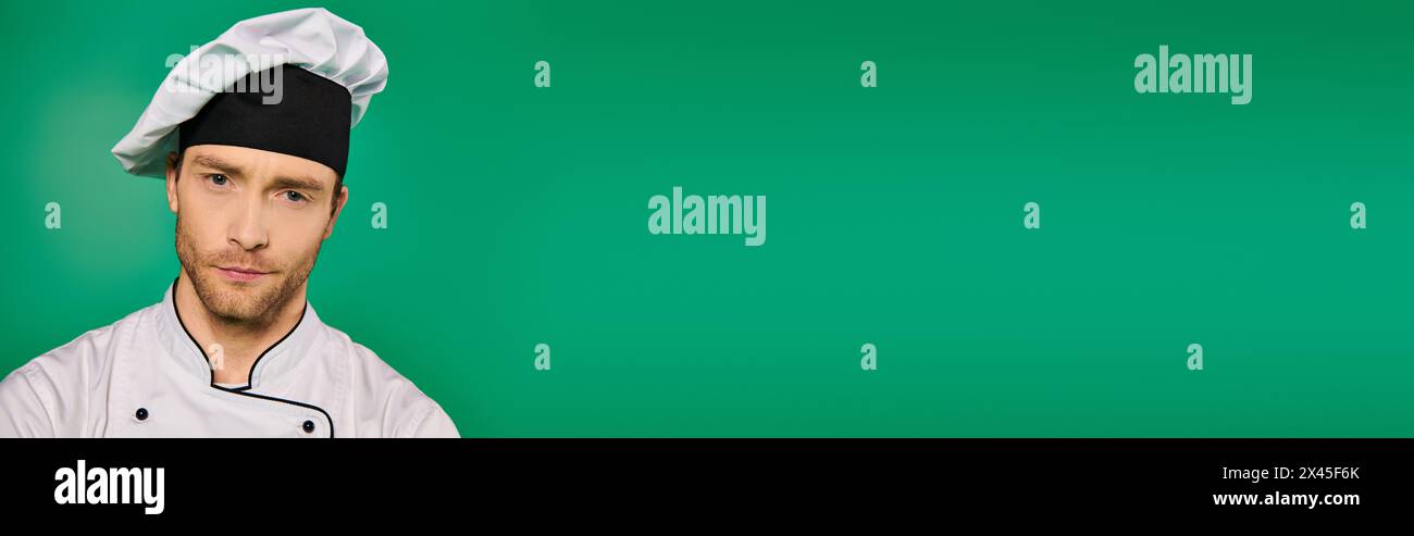 Handsome chef in white uniform proudly wearing chefs hat on green ...