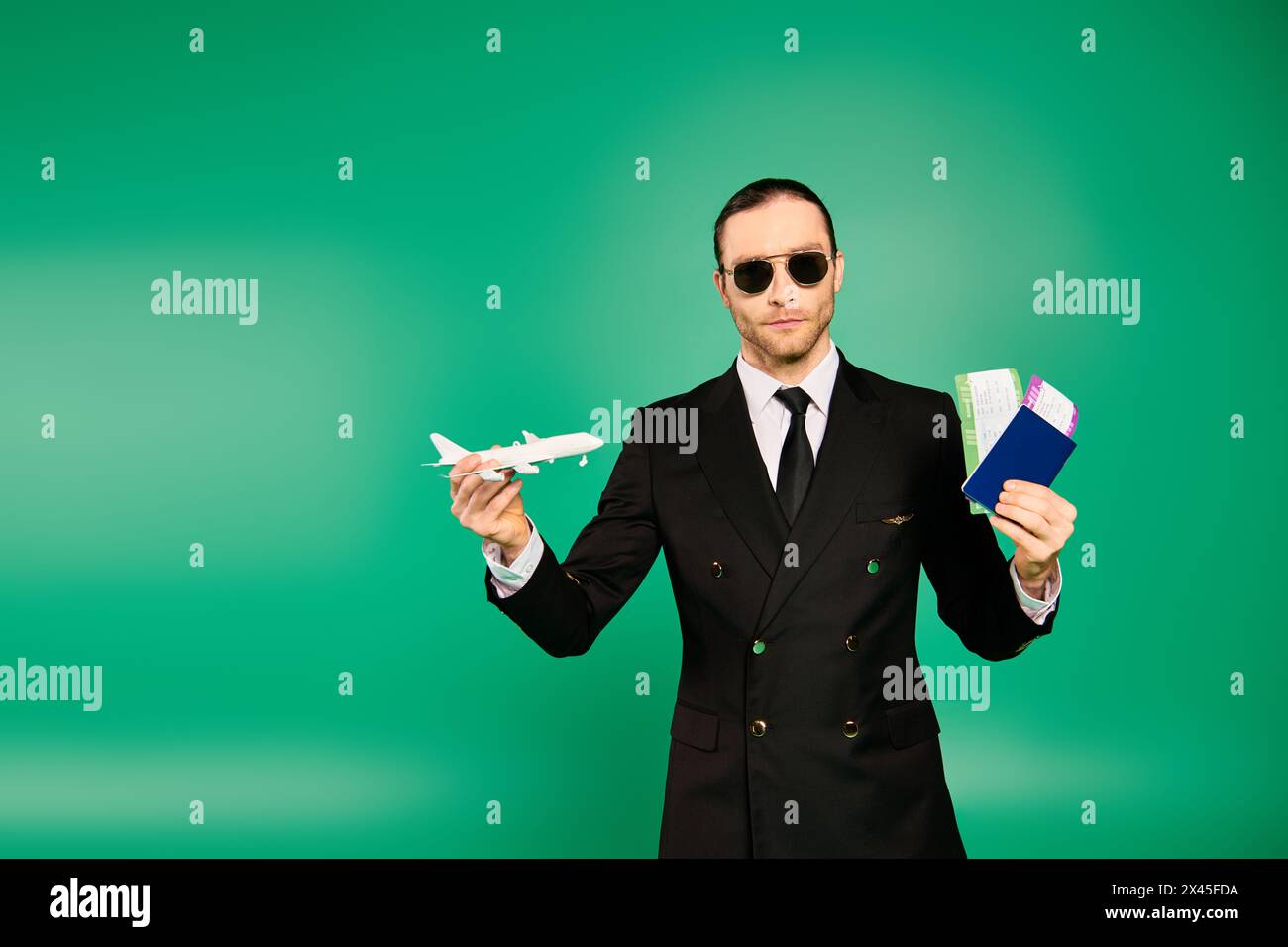 Handsome pilot in black suit poses with tickets and passport and model ...