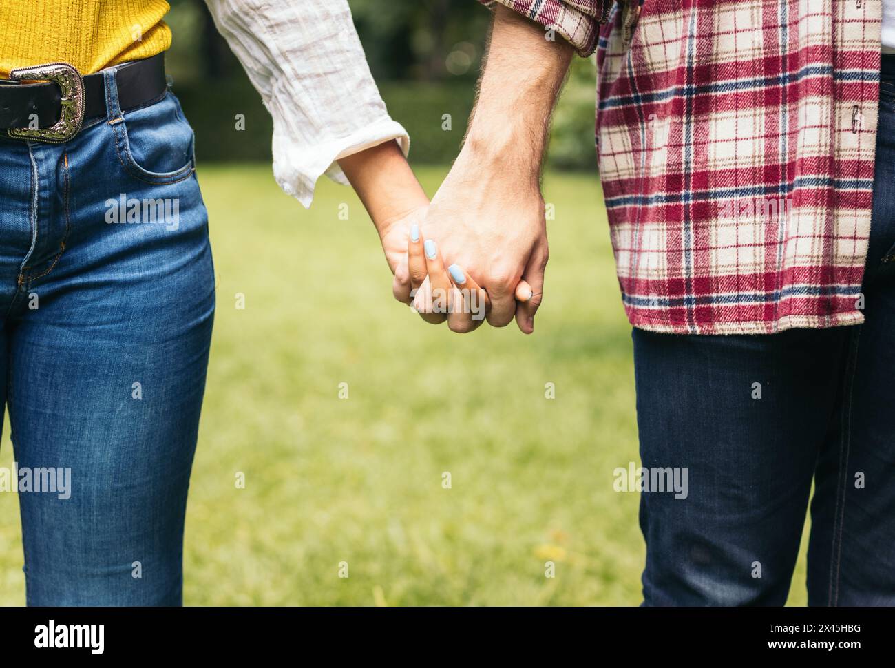 Close-up of the hands of an interracial couple interlocking their ...