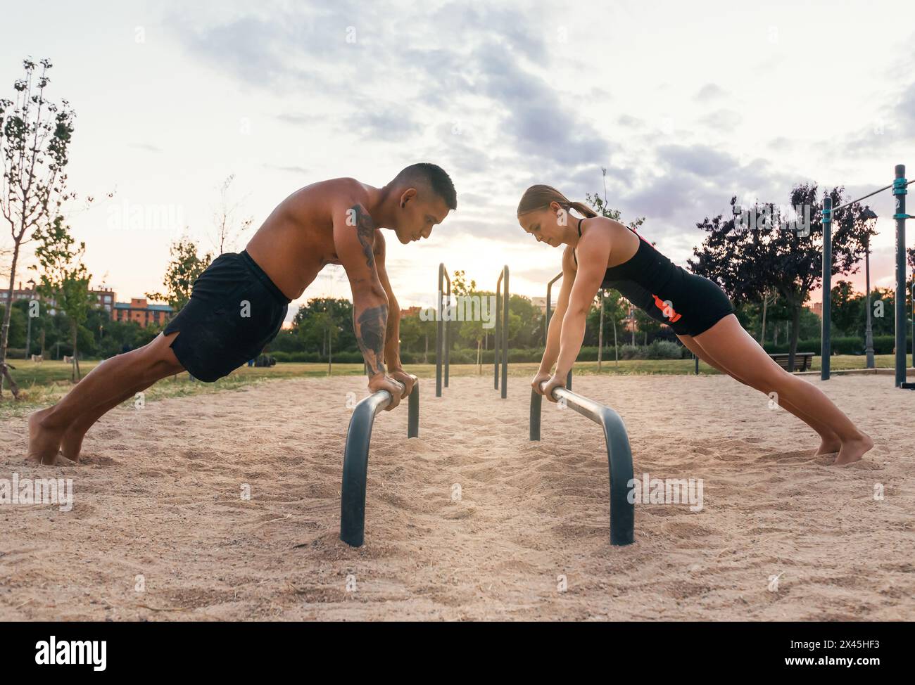 couple doing push ups on a bar in a calisthenic park Stock Photo - Alamy