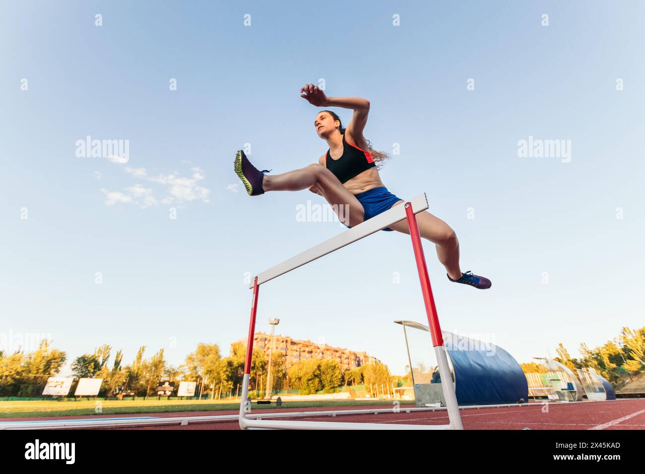 A strong woman in sports attire training for an obstacle race. She is ...