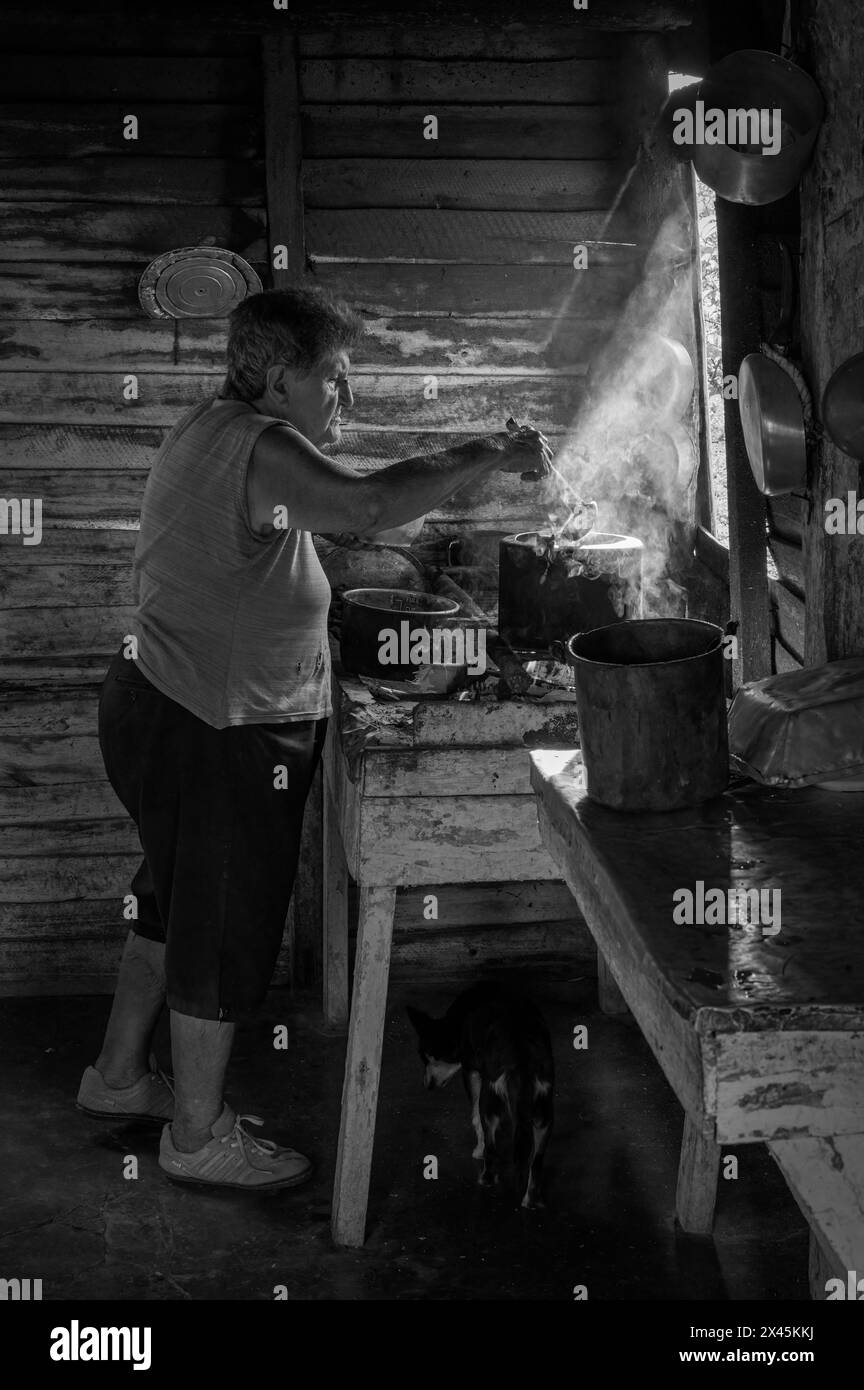 A coffee farmers wife in the farmhouse brewing coffee over an open fire ...