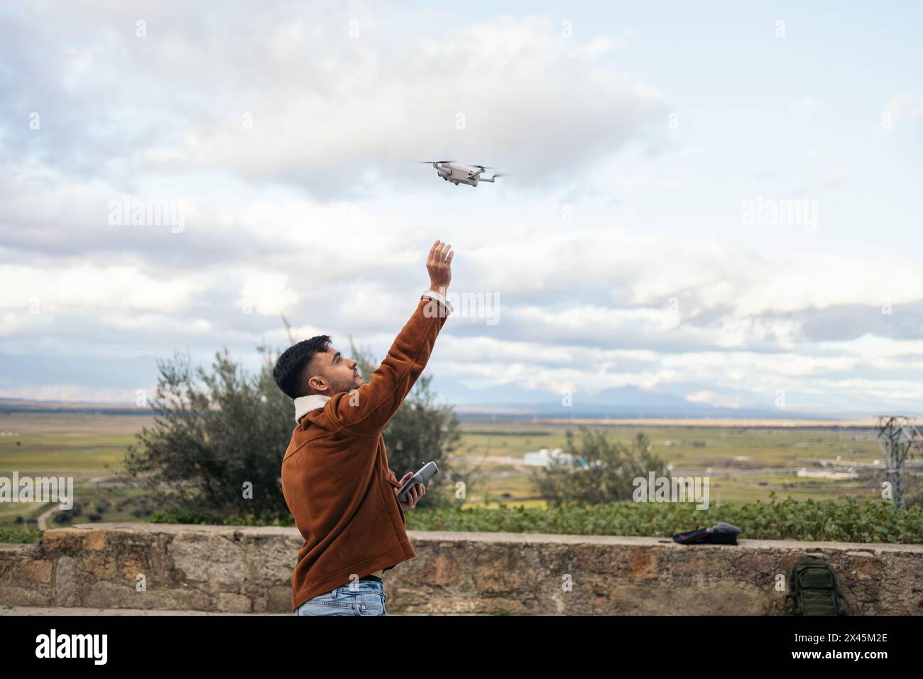 Young man using a drone to record and photograph the landscape. He ...