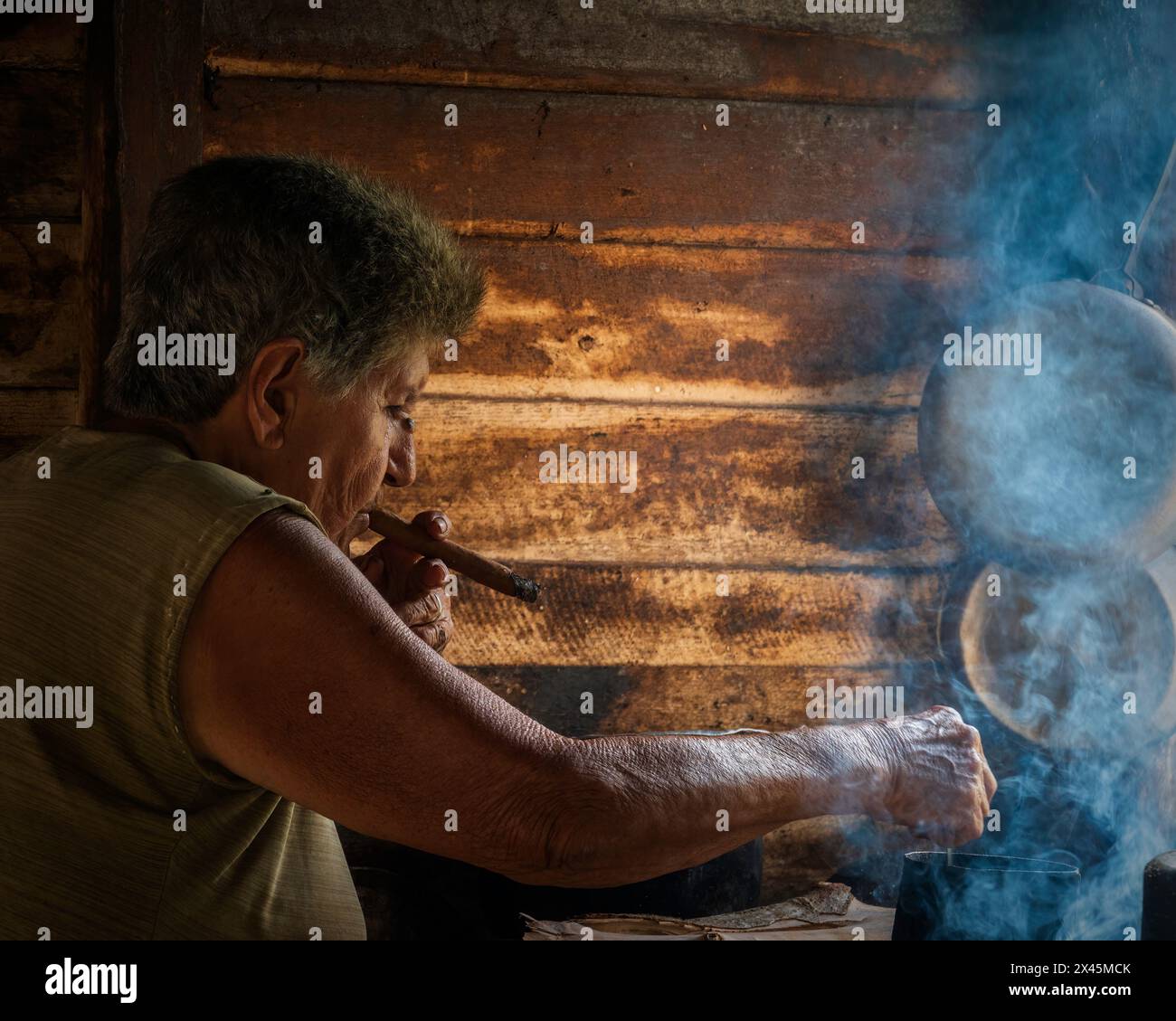 A coffee farmers wife smoking a cigar in the farmhouse while making the ...