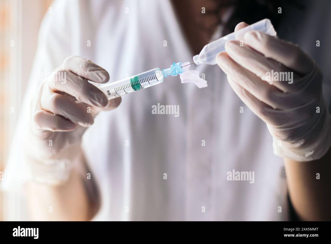 nurse injecting serum into a syringe Stock Photo - Alamy