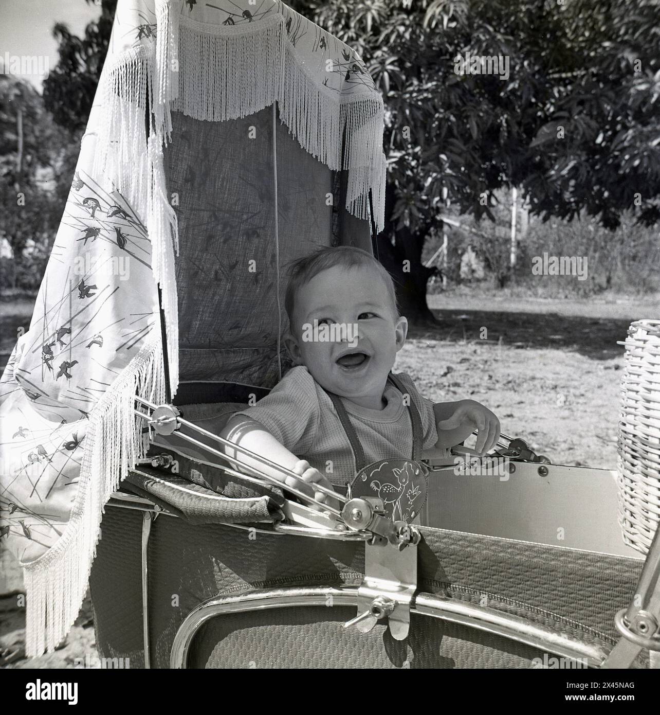 1960s, historical, an infant child sitting in a pushchair, with shade ...