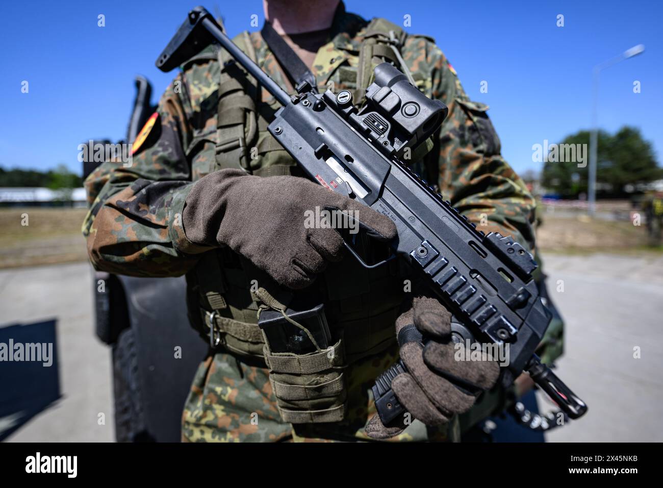30 April 2024, Saxony, Weißkeißel: A Bundeswehr soldier holds an MP7 ...